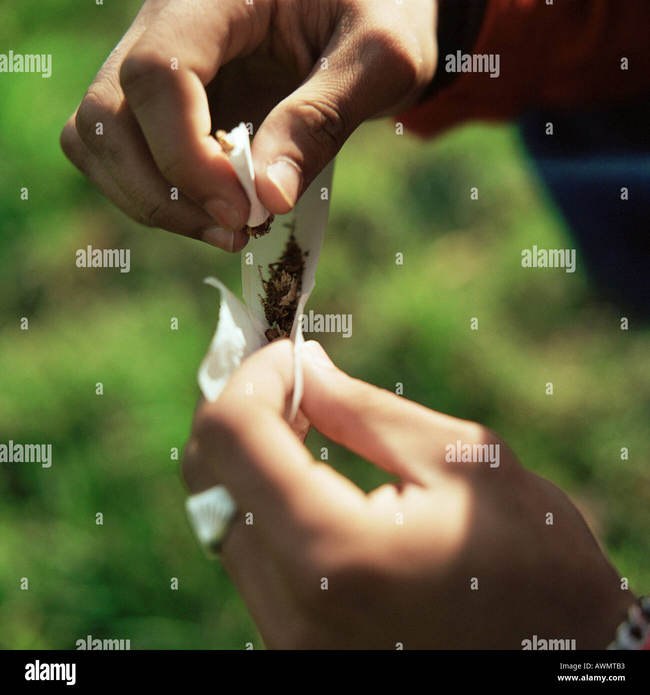 Young man's hands rolling a cigarette outside, close up Stock Photo - Alamy