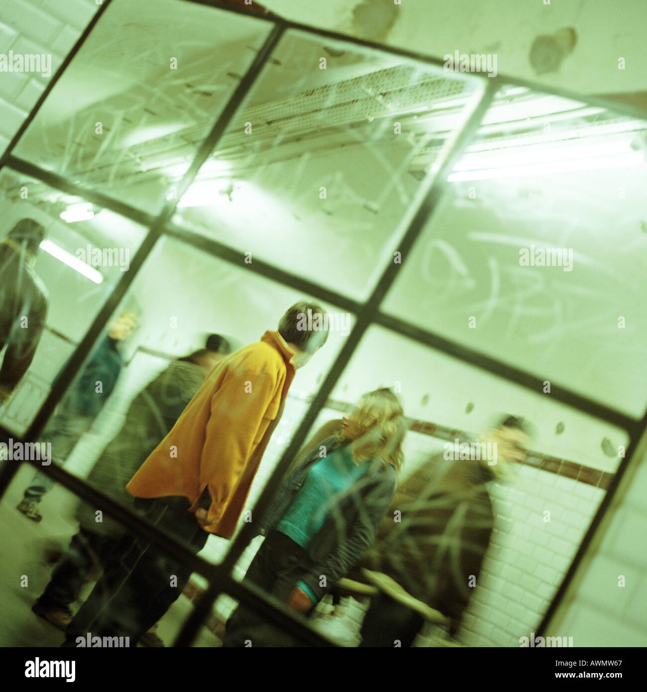 People walking through corridor, viewed through mirror Stock Photo - Alamy