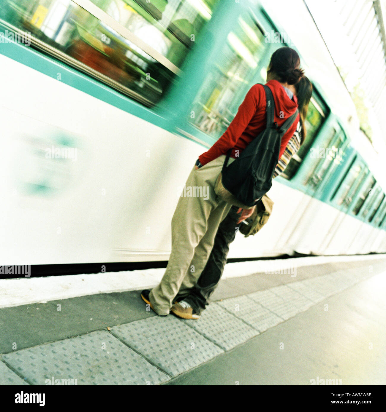 Young people standing on platform next to moving subway train Stock ...