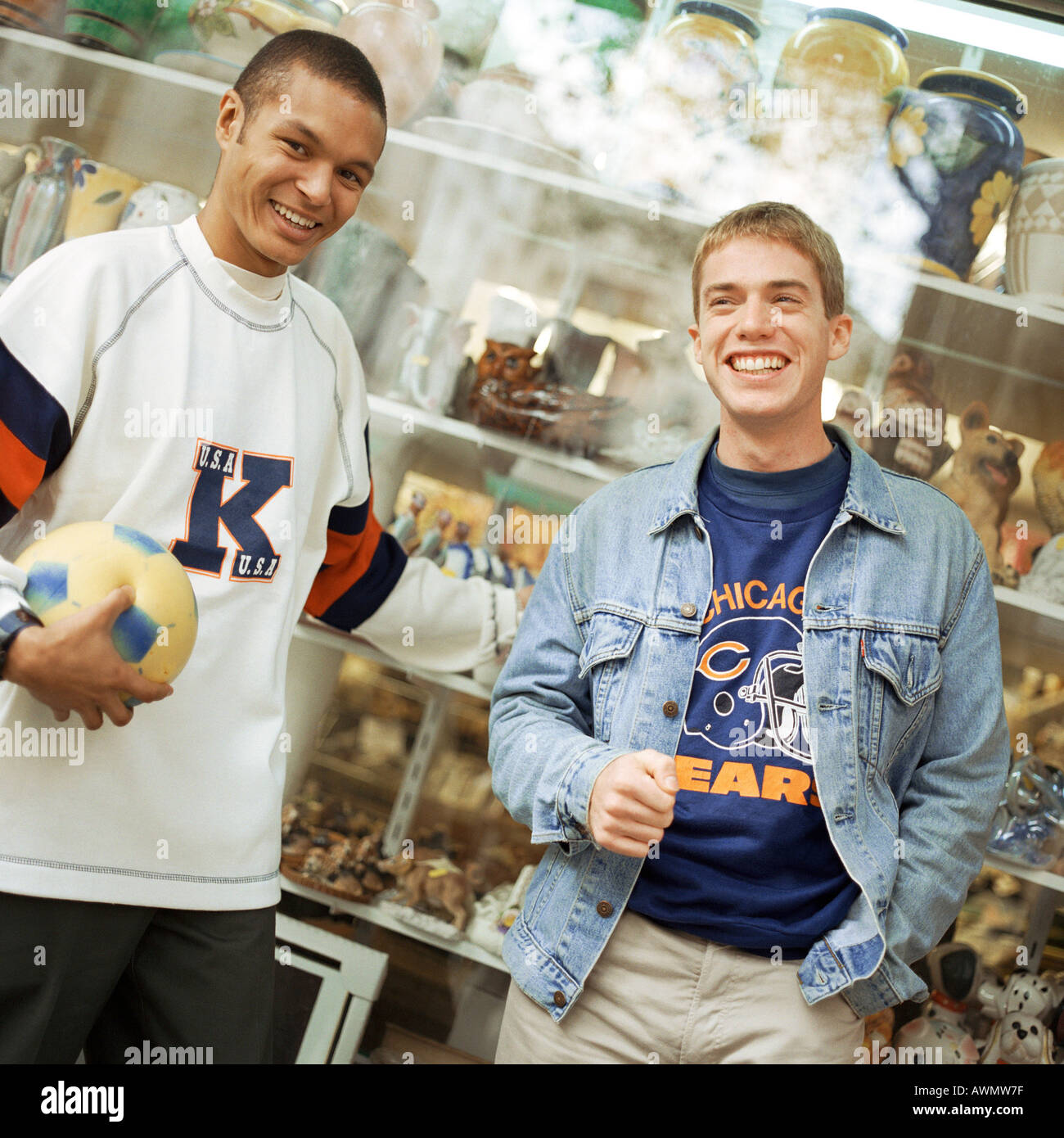 Young men leaning against store window, smiling, facing camera Stock ...