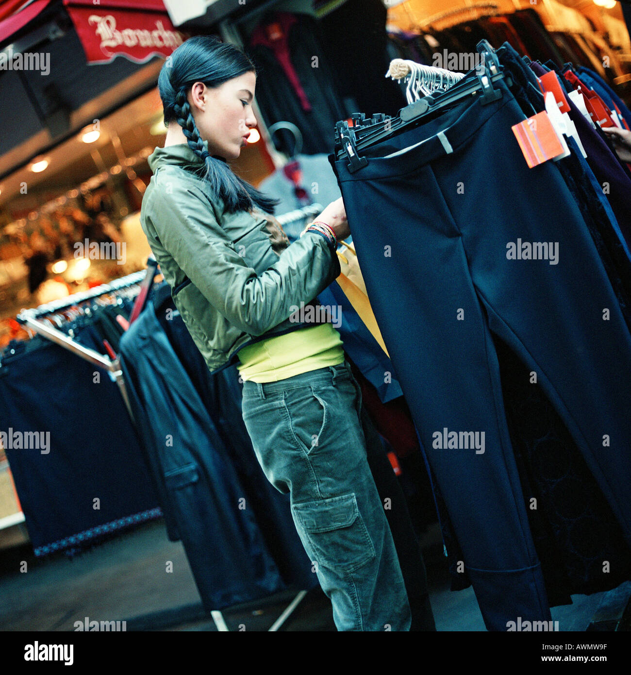 Teenage girl looking at racks of clothing, outside Stock Photo - Alamy
