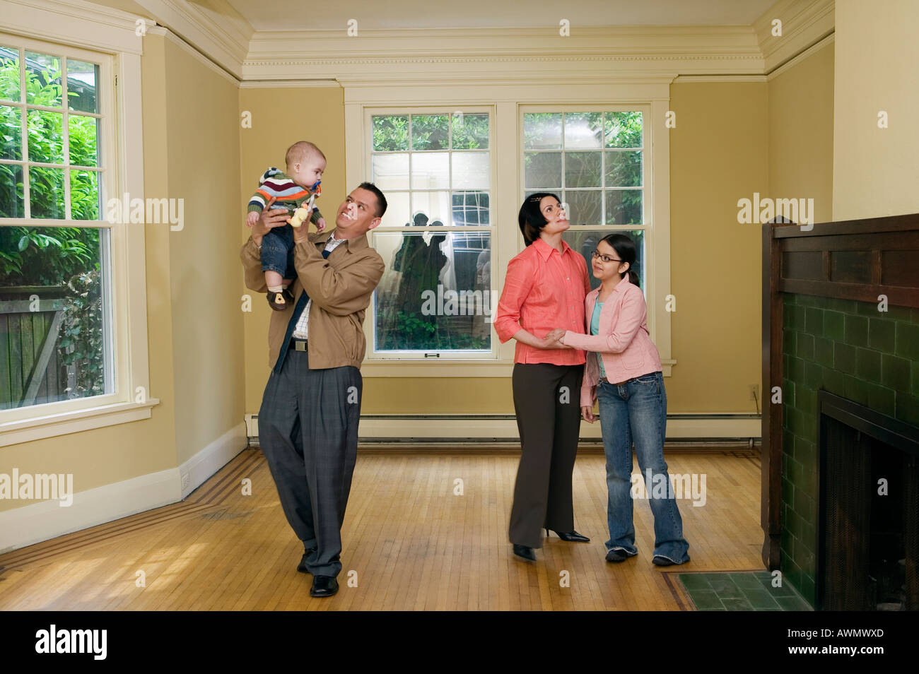 Hispanic family in empty room of new house Stock Photo - Alamy