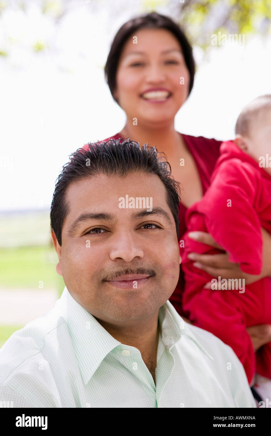 Hispanic father with family in background Stock Photo - Alamy