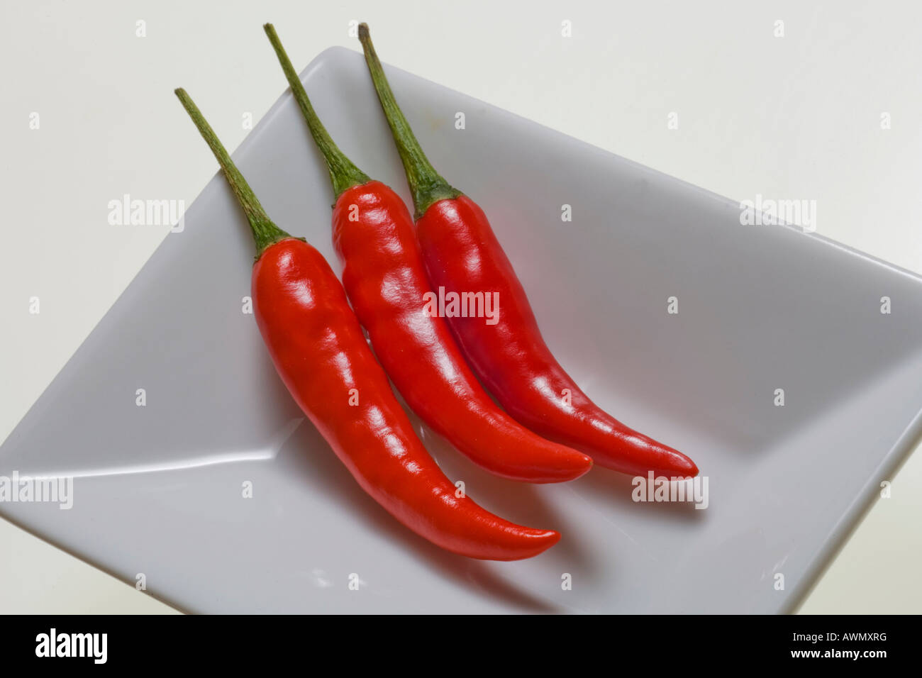 Three red chili peppers Stock Photo - Alamy