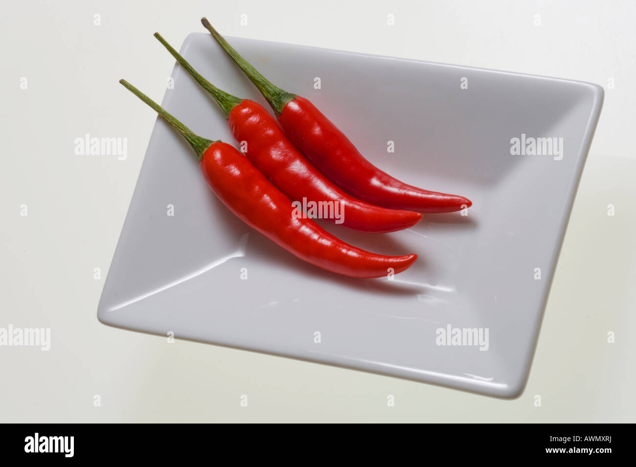 Three red chili peppers Stock Photo - Alamy