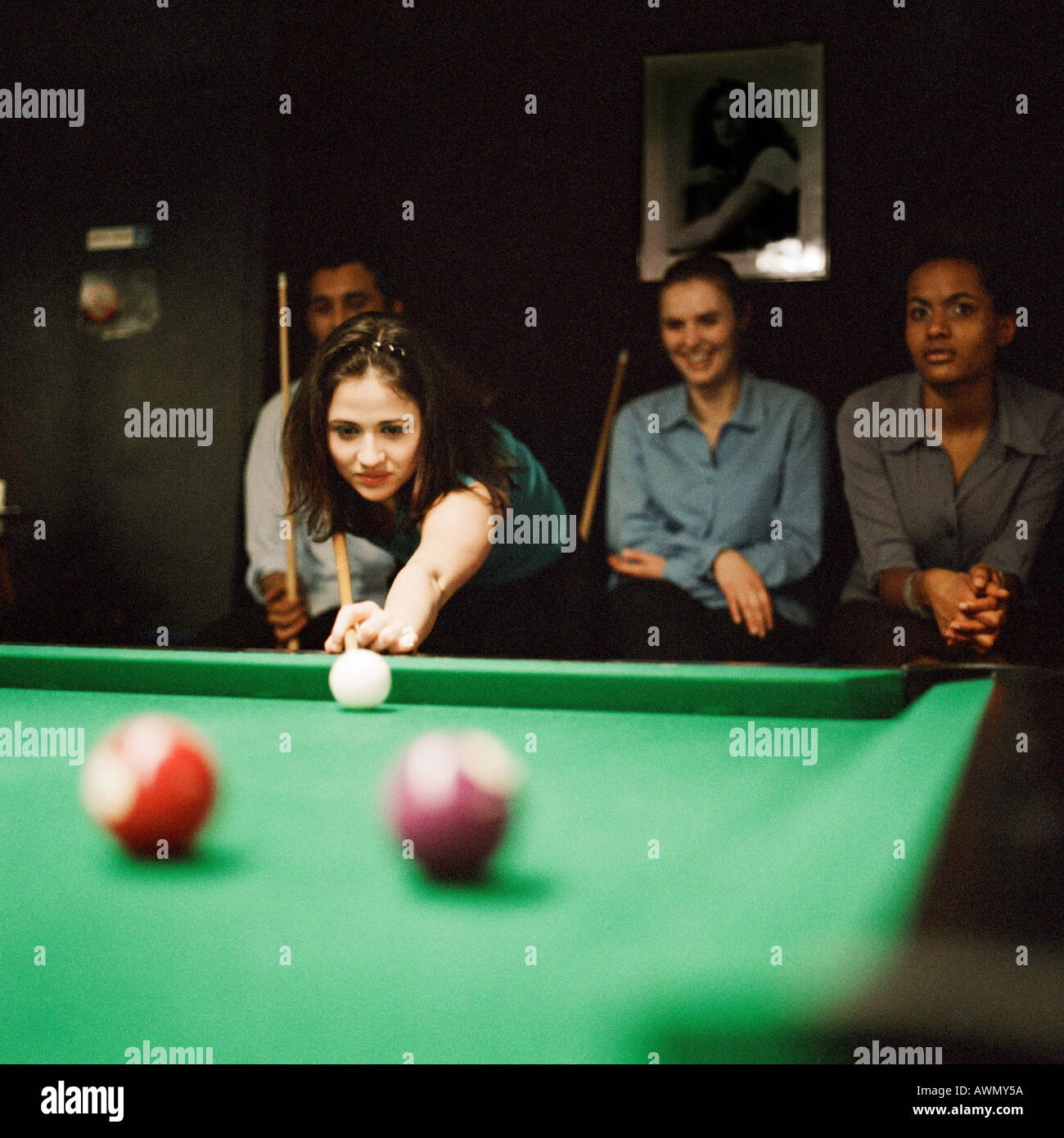 Young woman shooting pool, young people sitting in background Stock ...