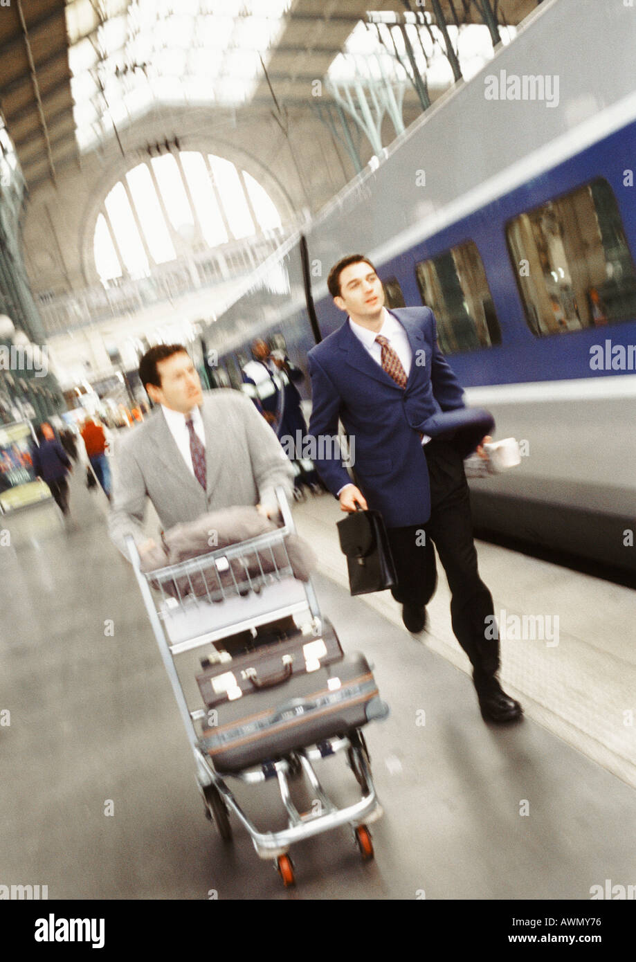 Businessmen running on train platform, blurred Stock Photo - Alamy