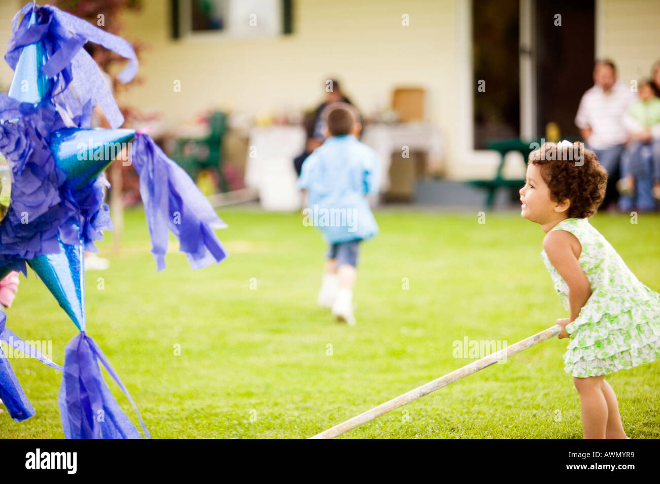 Hispanic girl hitting pinata Stock Photo - Alamy
