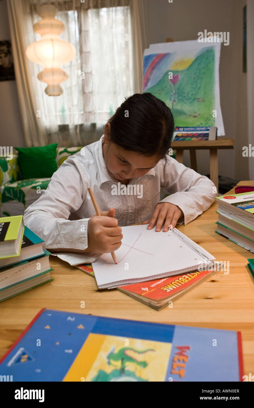 Young schoolgirl doing homework in nursery, drawing angrily in her ...