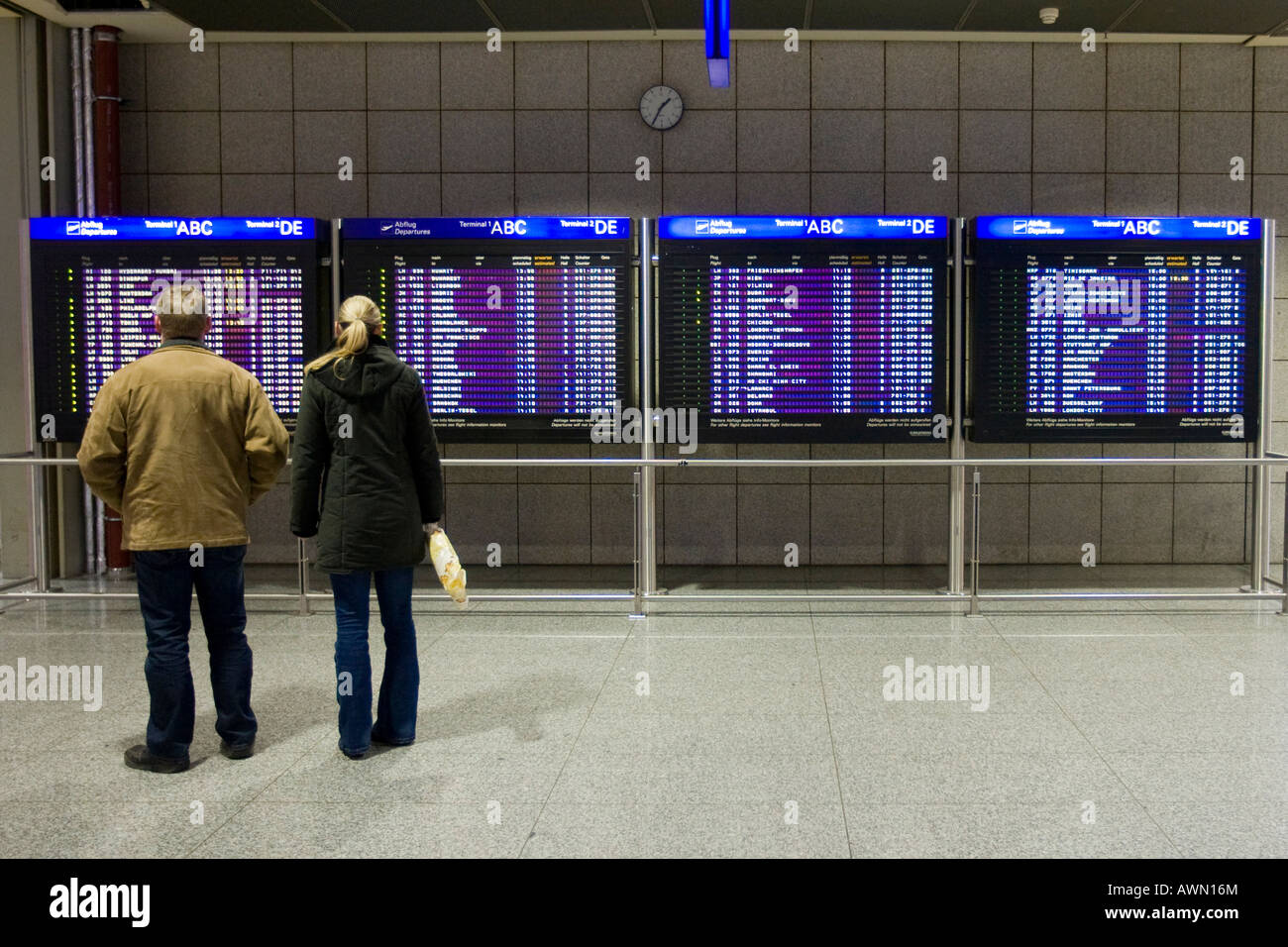 Passengers in front of flight info display screens, Terminal 2 ...