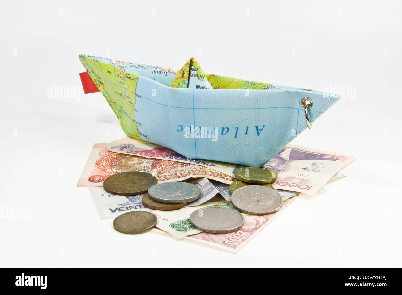 Foreign currency and a paper ship made from a map: symbol for ...