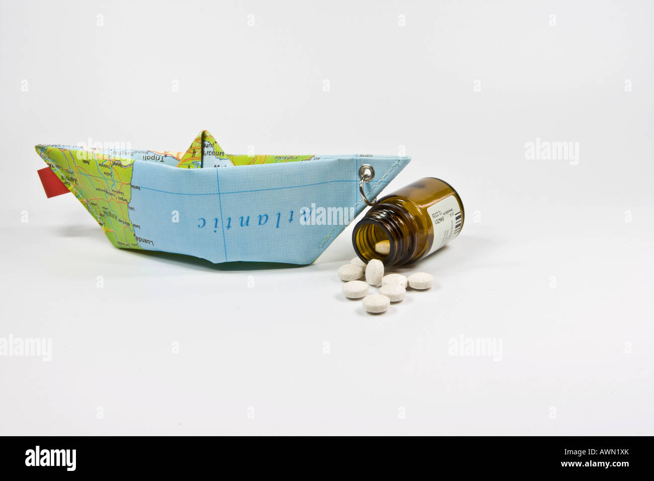 Pills and a paper ship made from a map: symbol for anti-seasickness ...