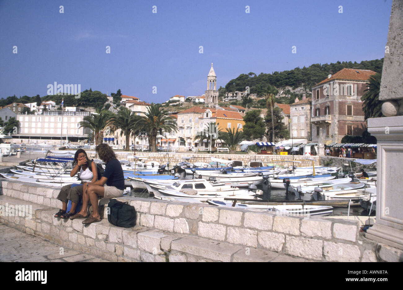 Two girls sitting on the Dubrovnik Harbor wall Stock Photo - Alamy