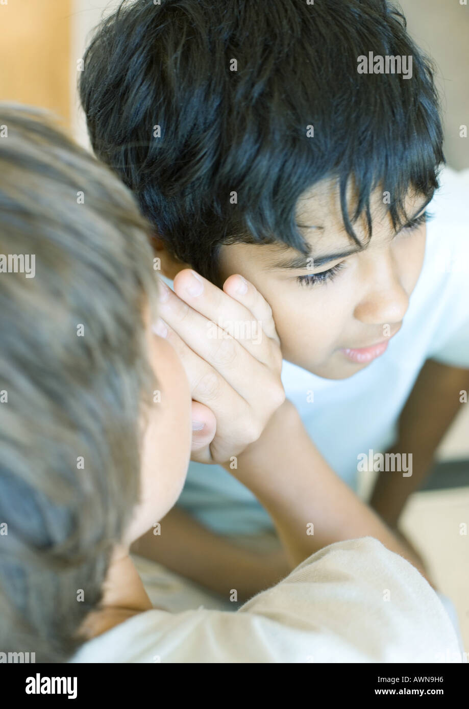 Teen boy whispering to friend Stock Photo - Alamy