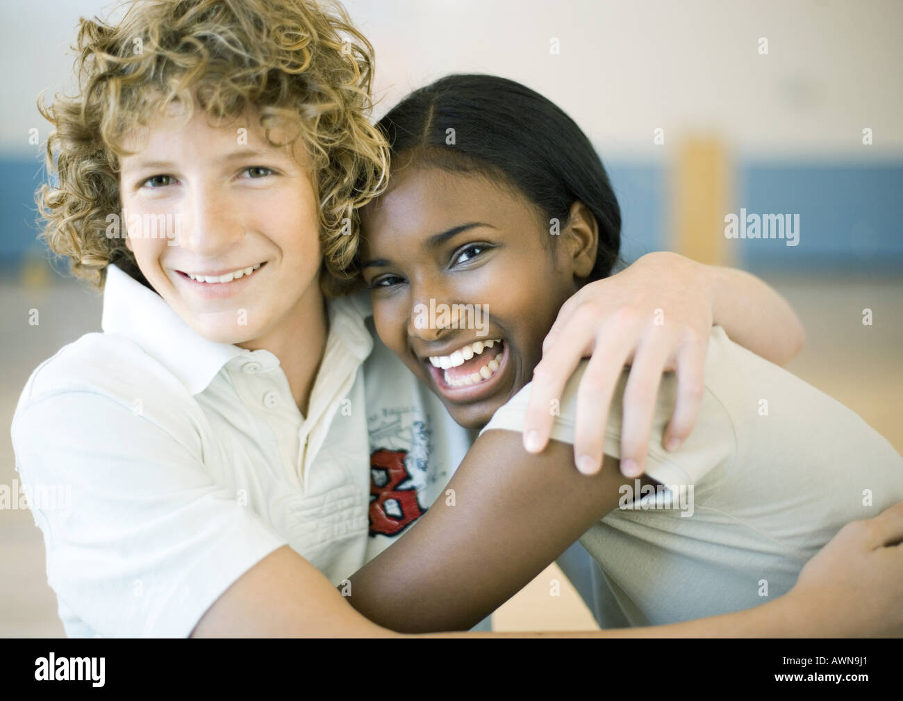 Teen couple sitting with arms around each other Stock Photo - Alamy