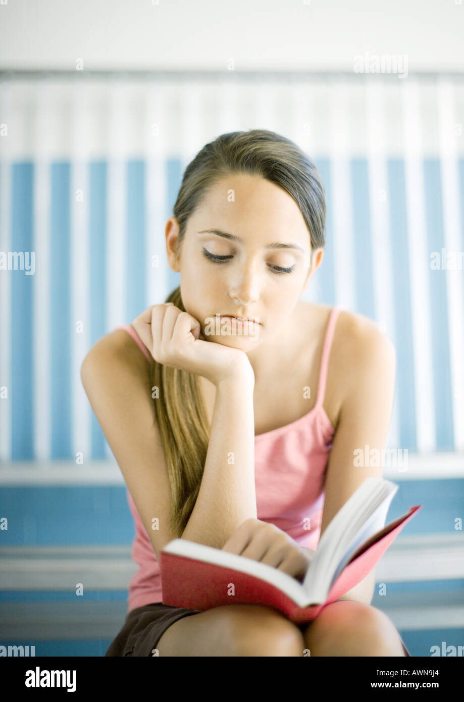 Teen girl reading book on bleachers Stock Photo - Alamy