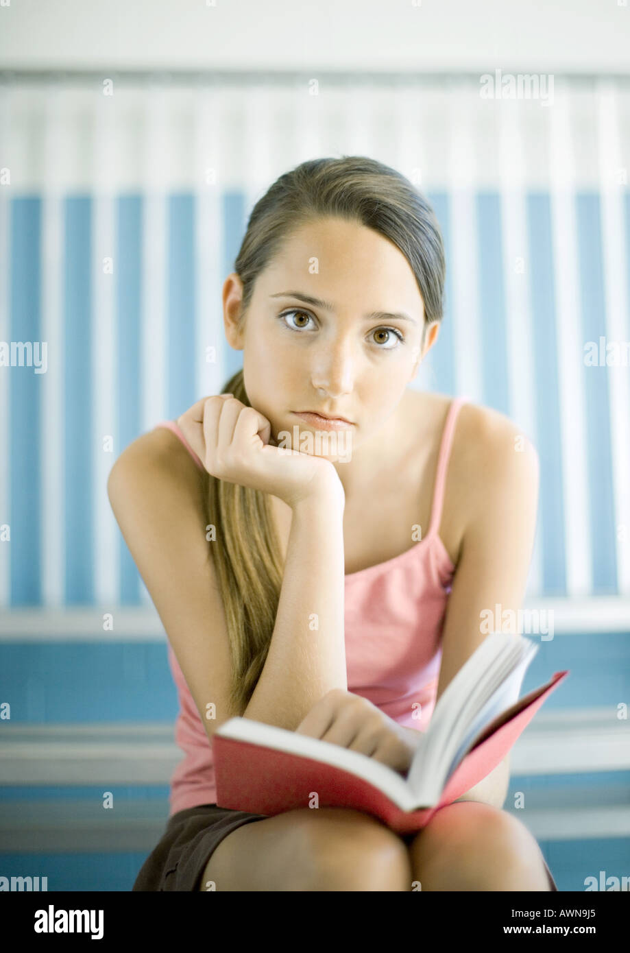 Teen girl reading book on bleachers Stock Photo - Alamy