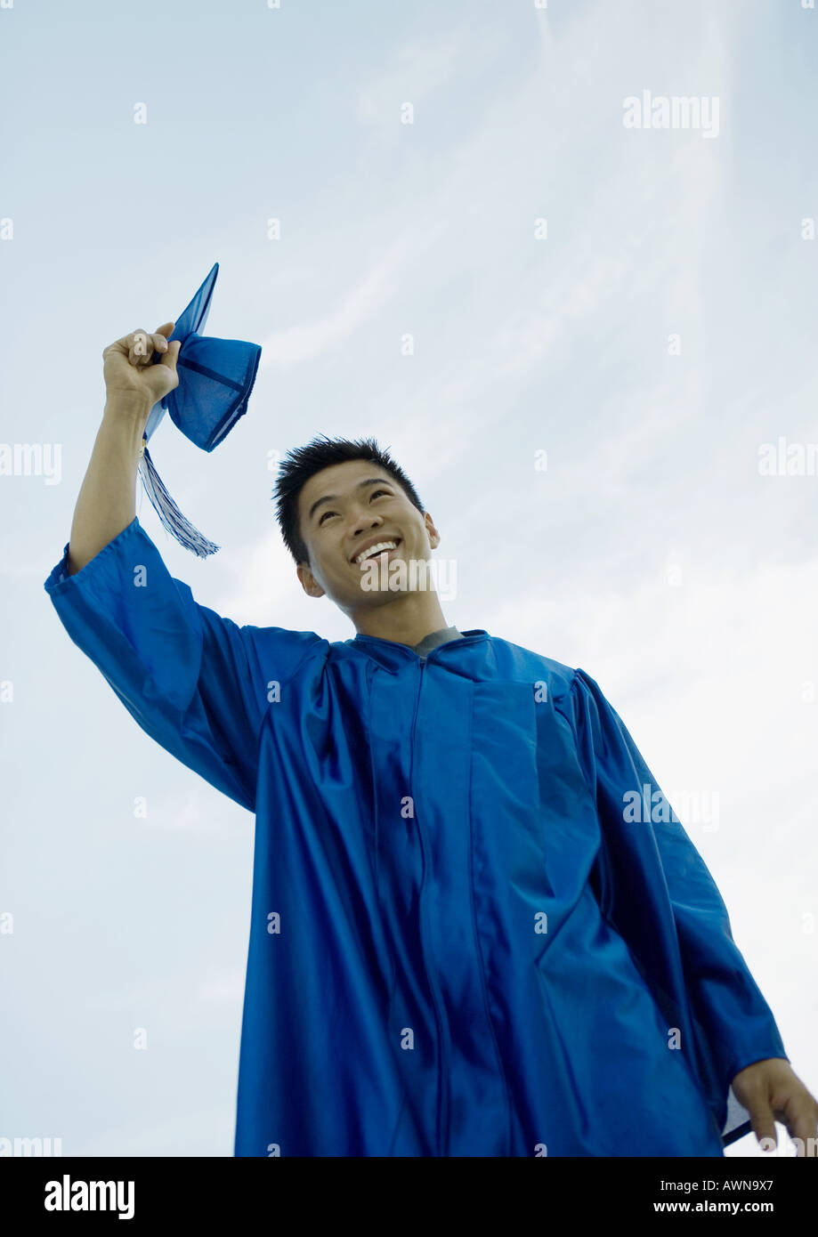 Male graduate taking off cap Stock Photo - Alamy