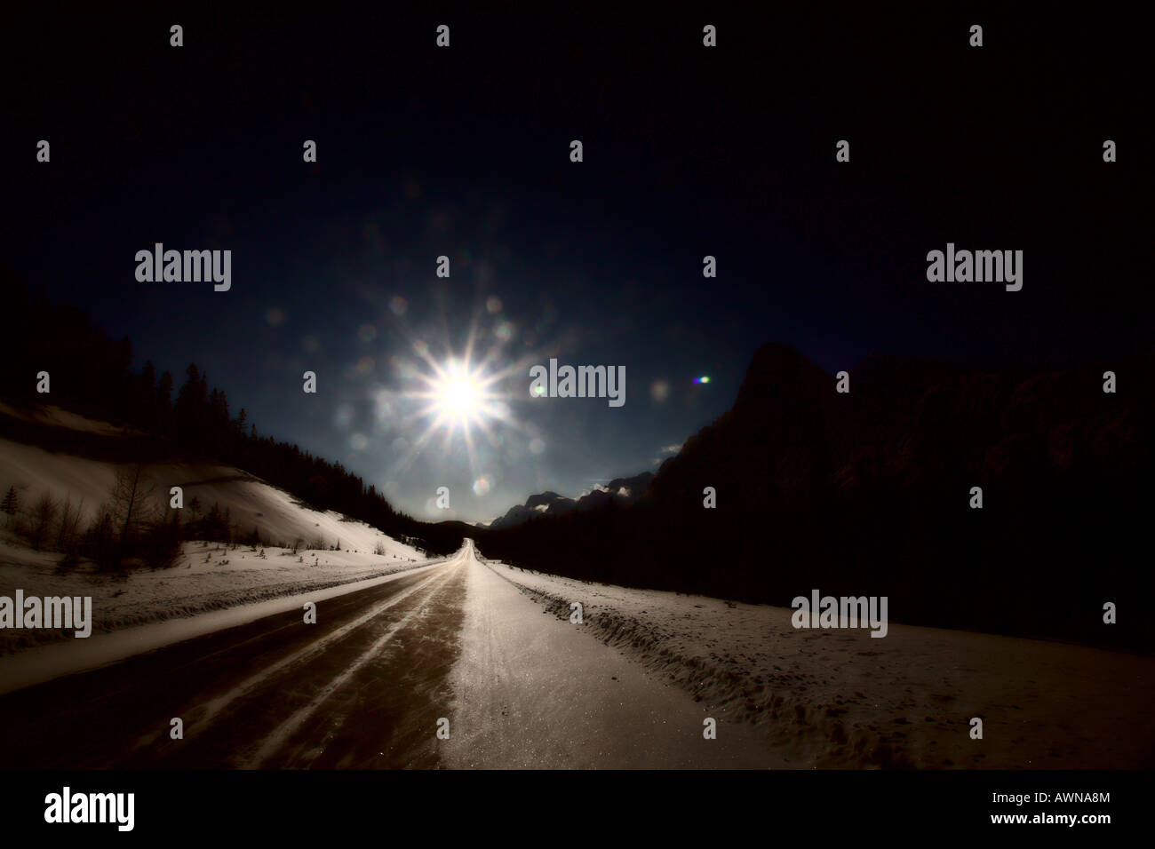 Sun glare down winter road Stock Photo - Alamy