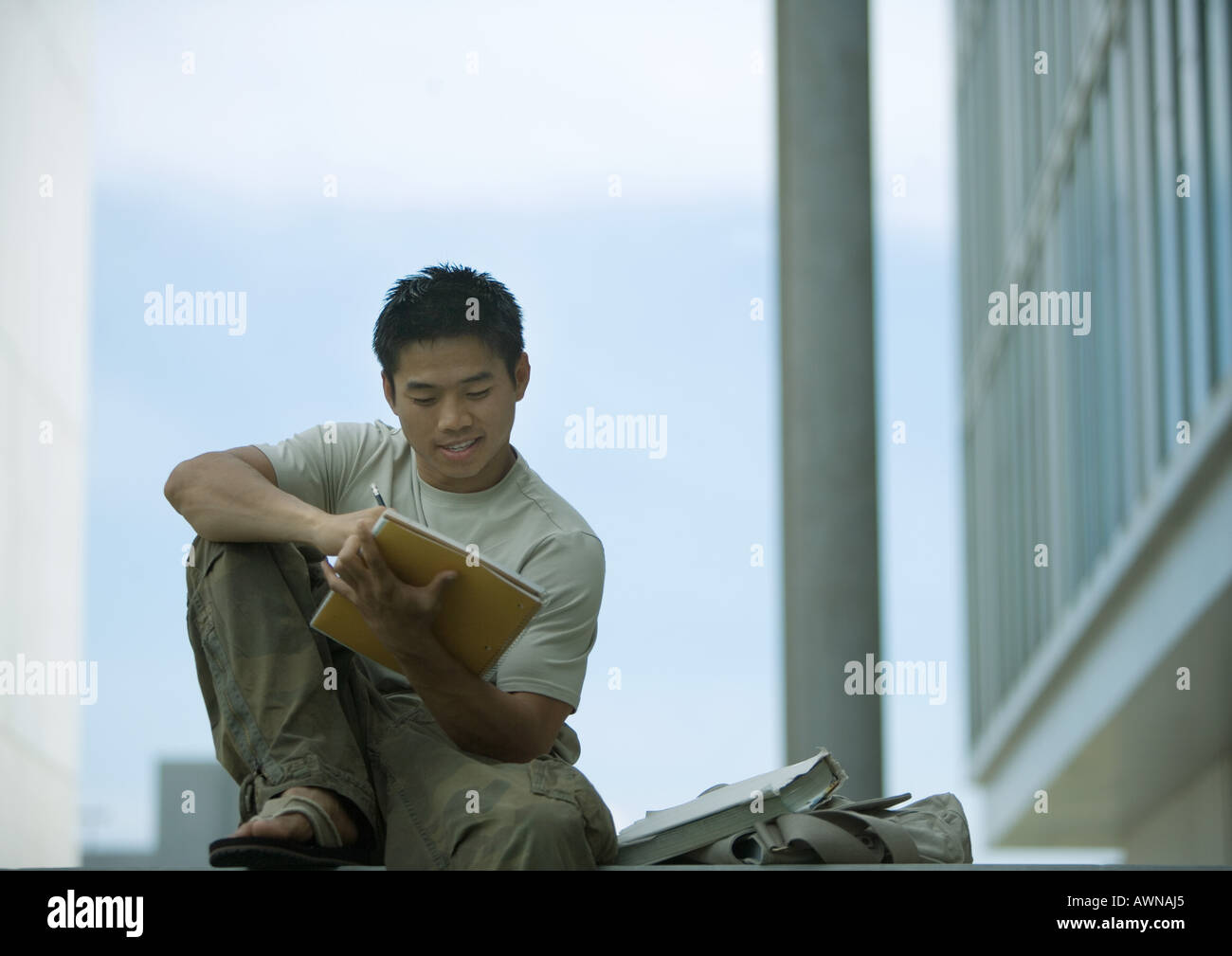 Young man studying outdoors on campus Stock Photo - Alamy