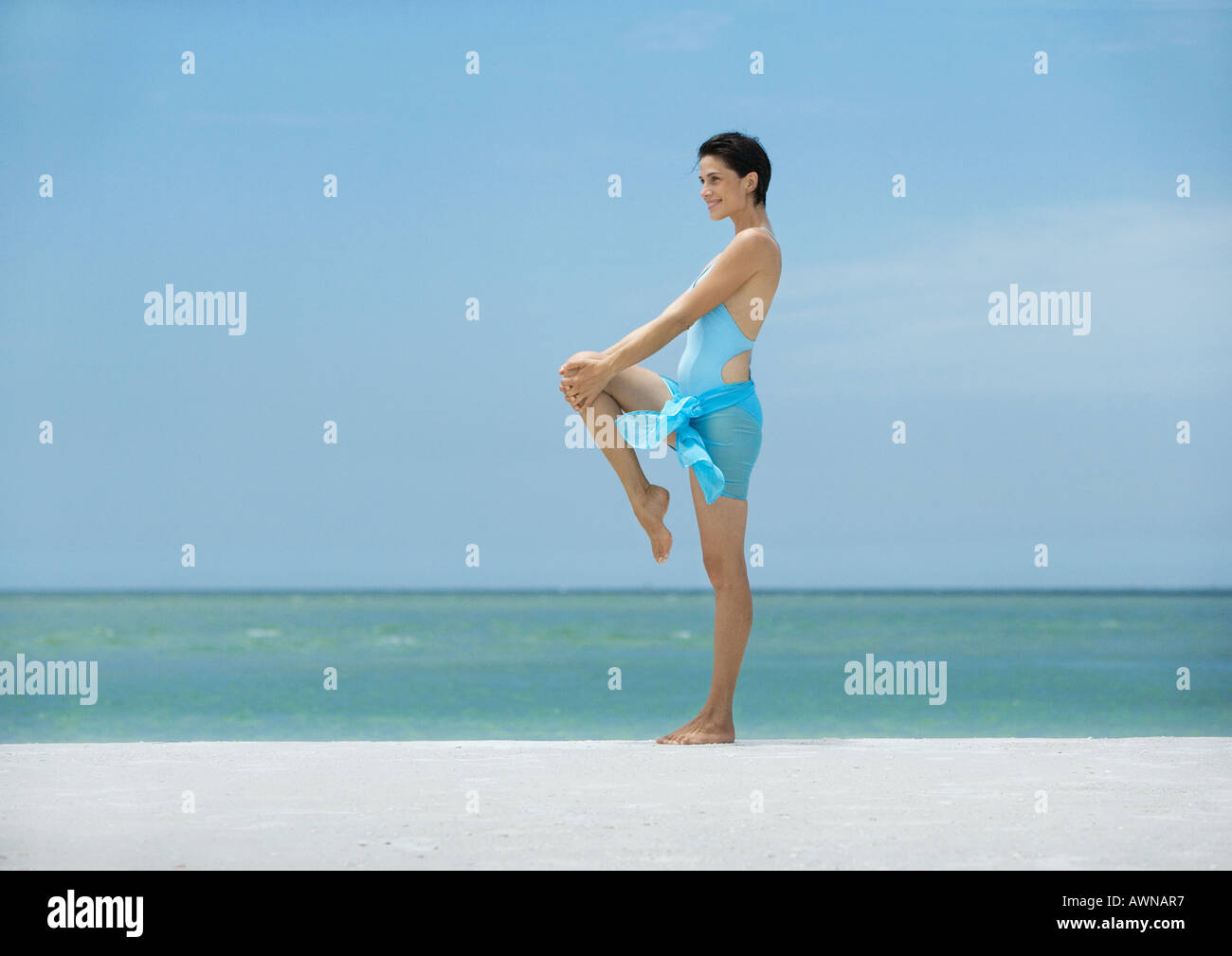 Woman stretching on beach Stock Photo - Alamy