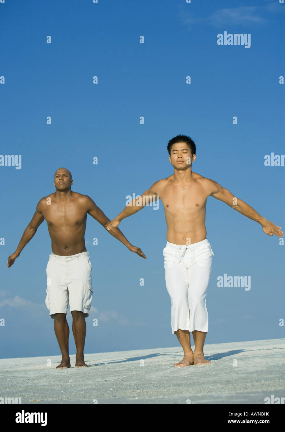 Two men doing relaxation exercises on the beach Stock Photo - Alamy