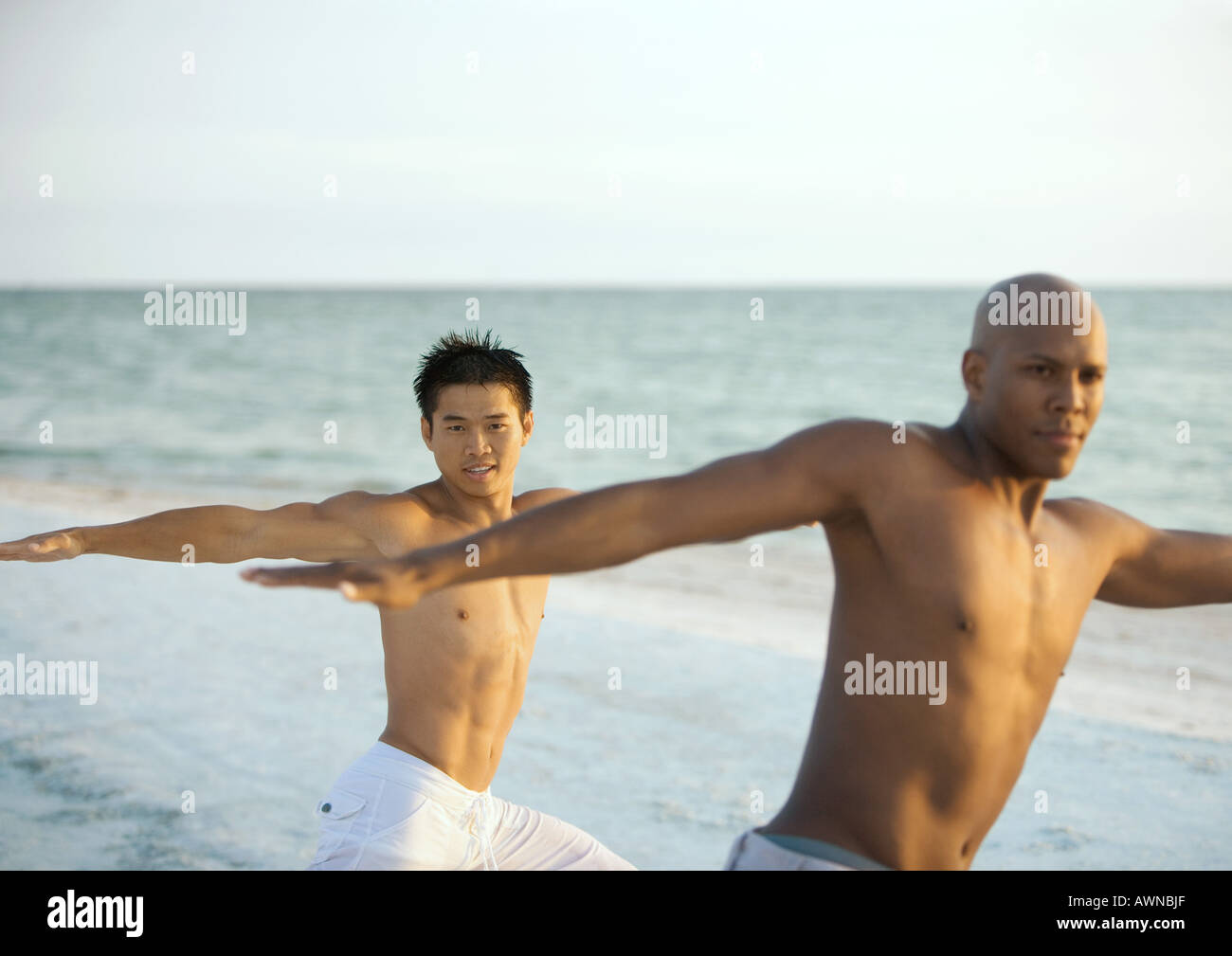 Two men doing relaxation exercise on beach Stock Photo - Alamy