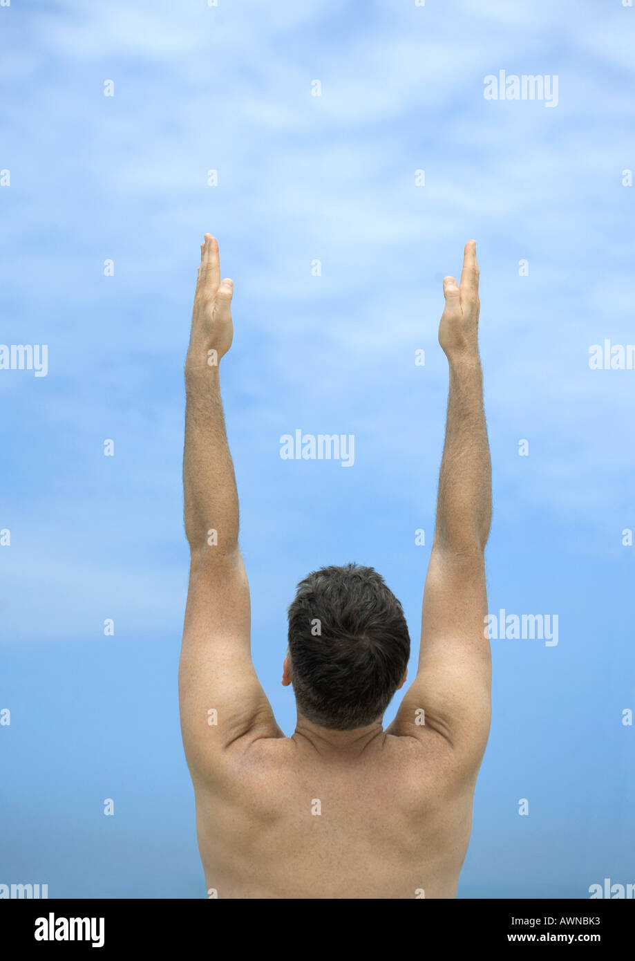 Man with arms raised, rear view Stock Photo - Alamy