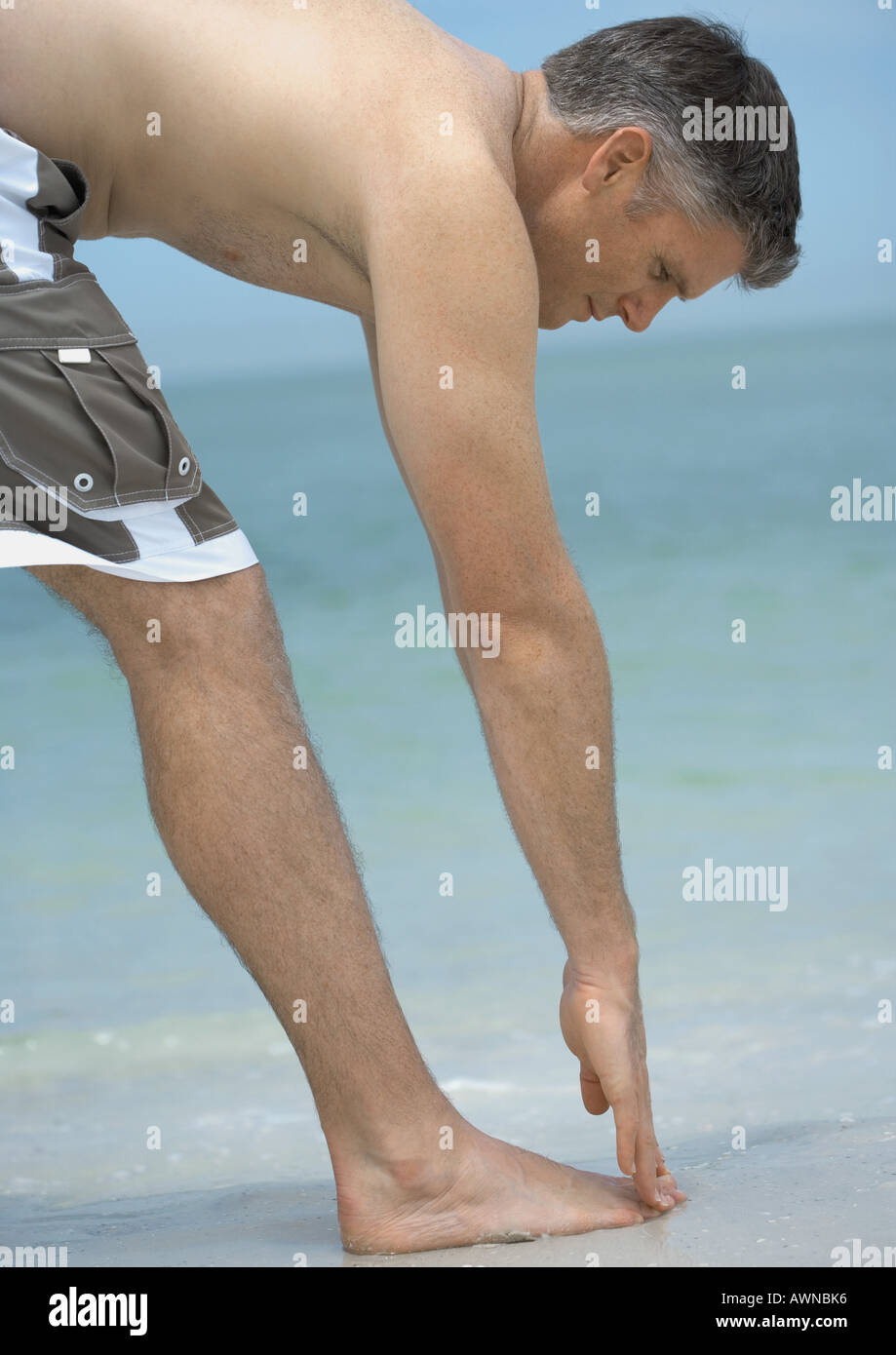 Man touching toes Stock Photo - Alamy