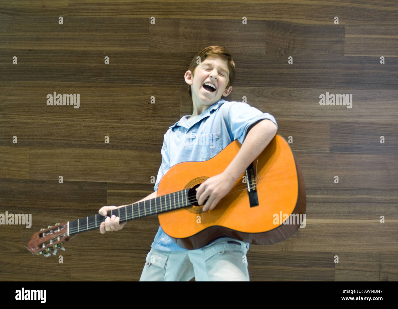 Boy playing guitar and singing Stock Photo - Alamy