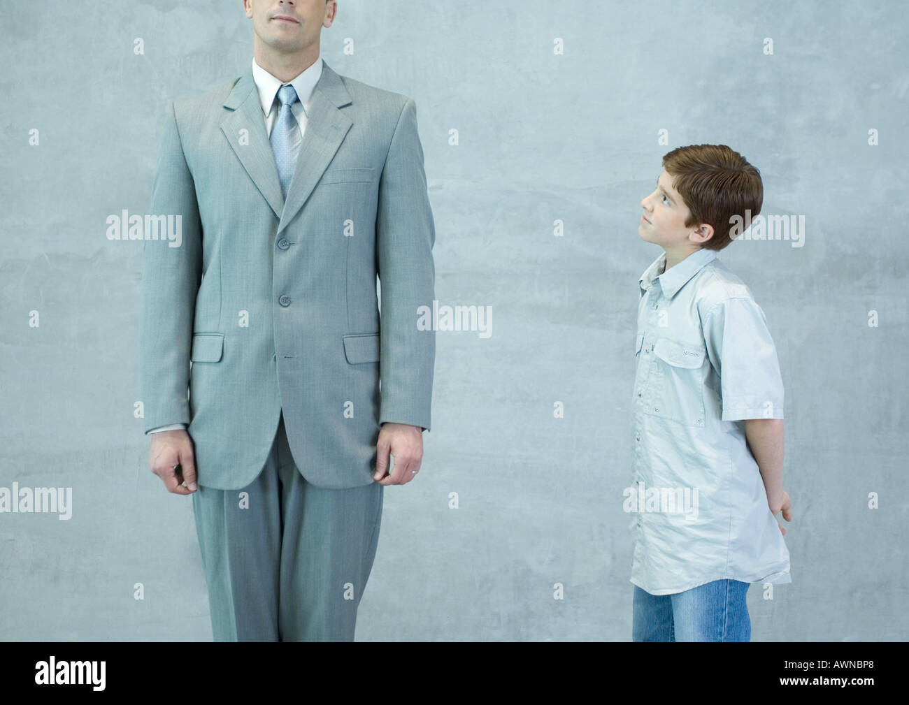 Boy looking up at businessman Stock Photo - Alamy