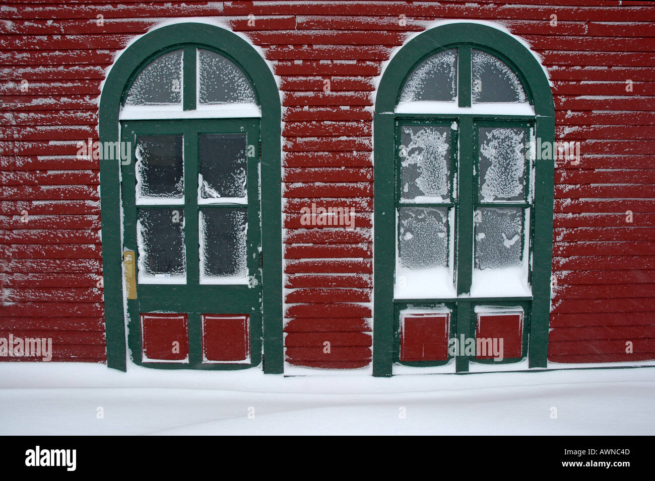 Snow and ice form on a window during a winter blizzard to create a ...