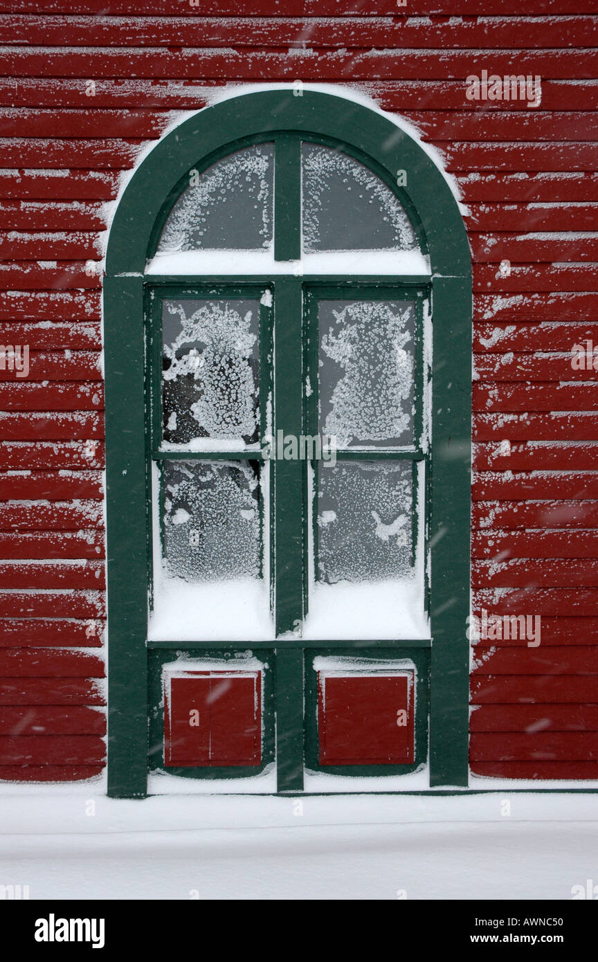 Snow and ice form on a window during a winter blizzard to create a ...