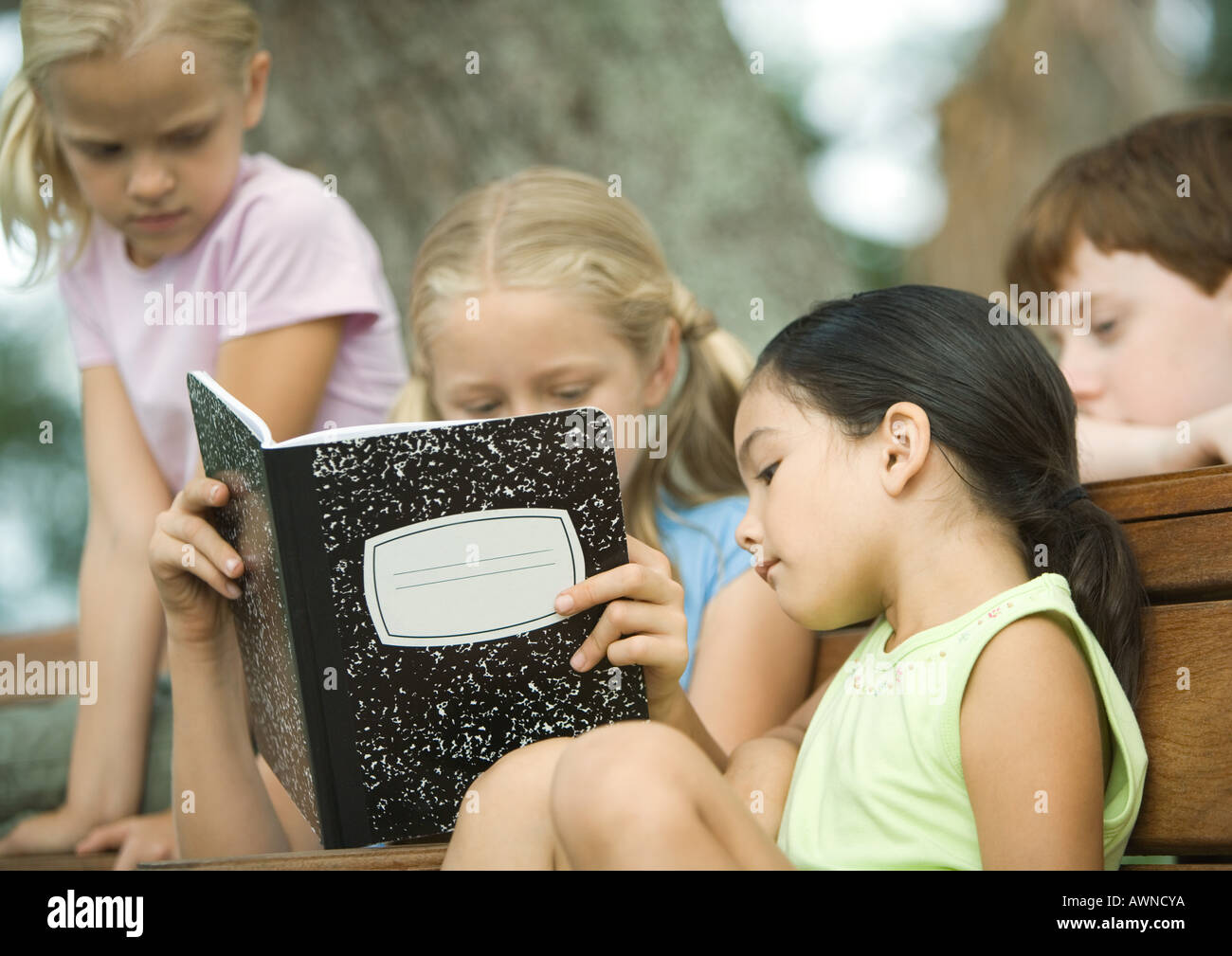 Group of children looking at notebook together Stock Photo - Alamy