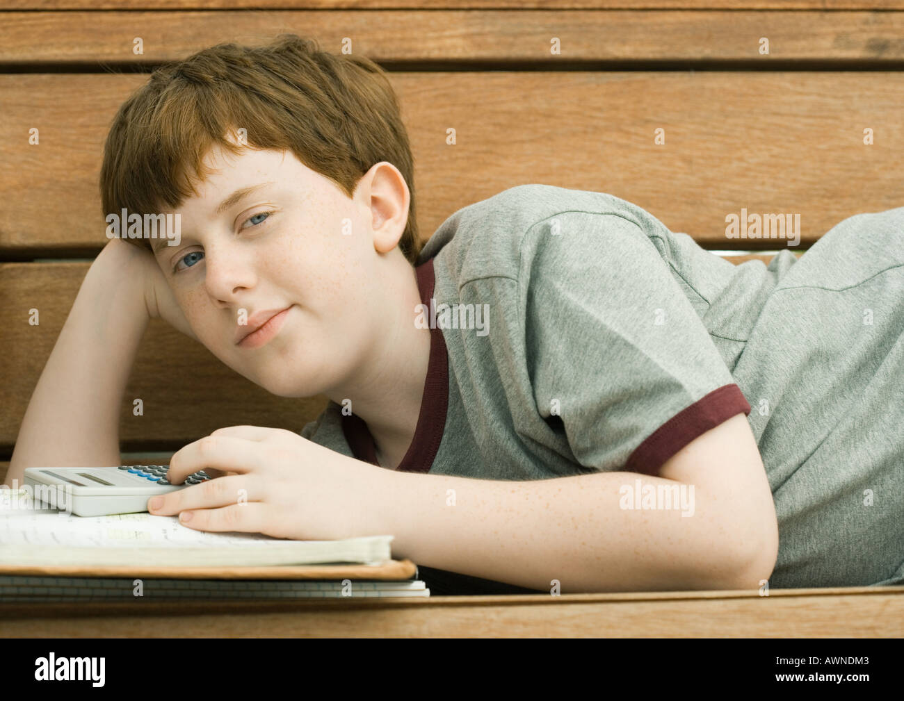 Boy lying on bench with homework Stock Photo - Alamy