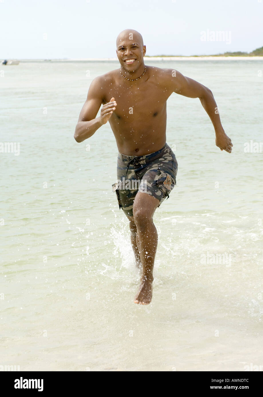 Man running through surf Stock Photo - Alamy