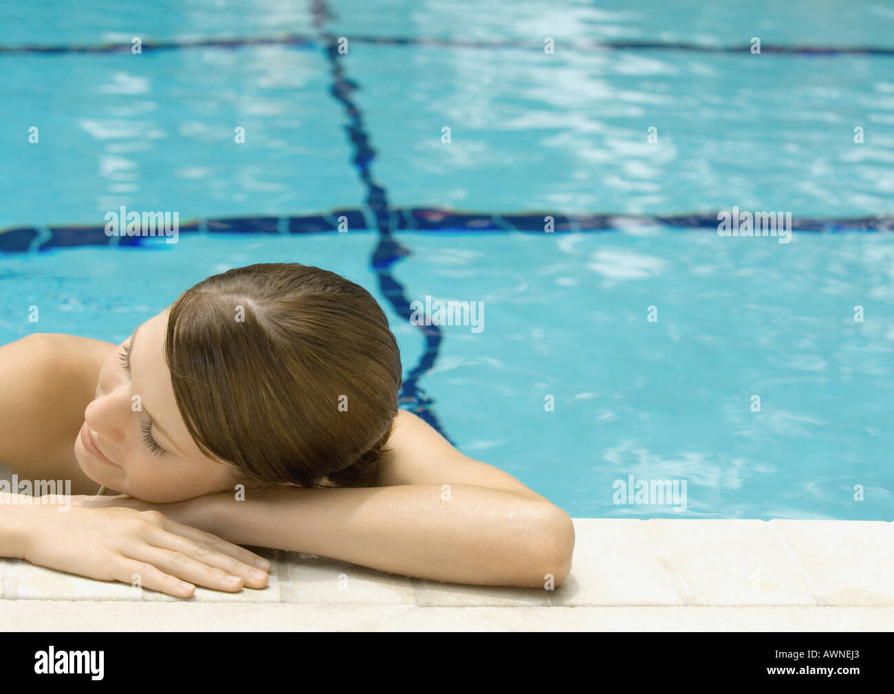 Young woman resting head on side of pool Stock Photo - Alamy