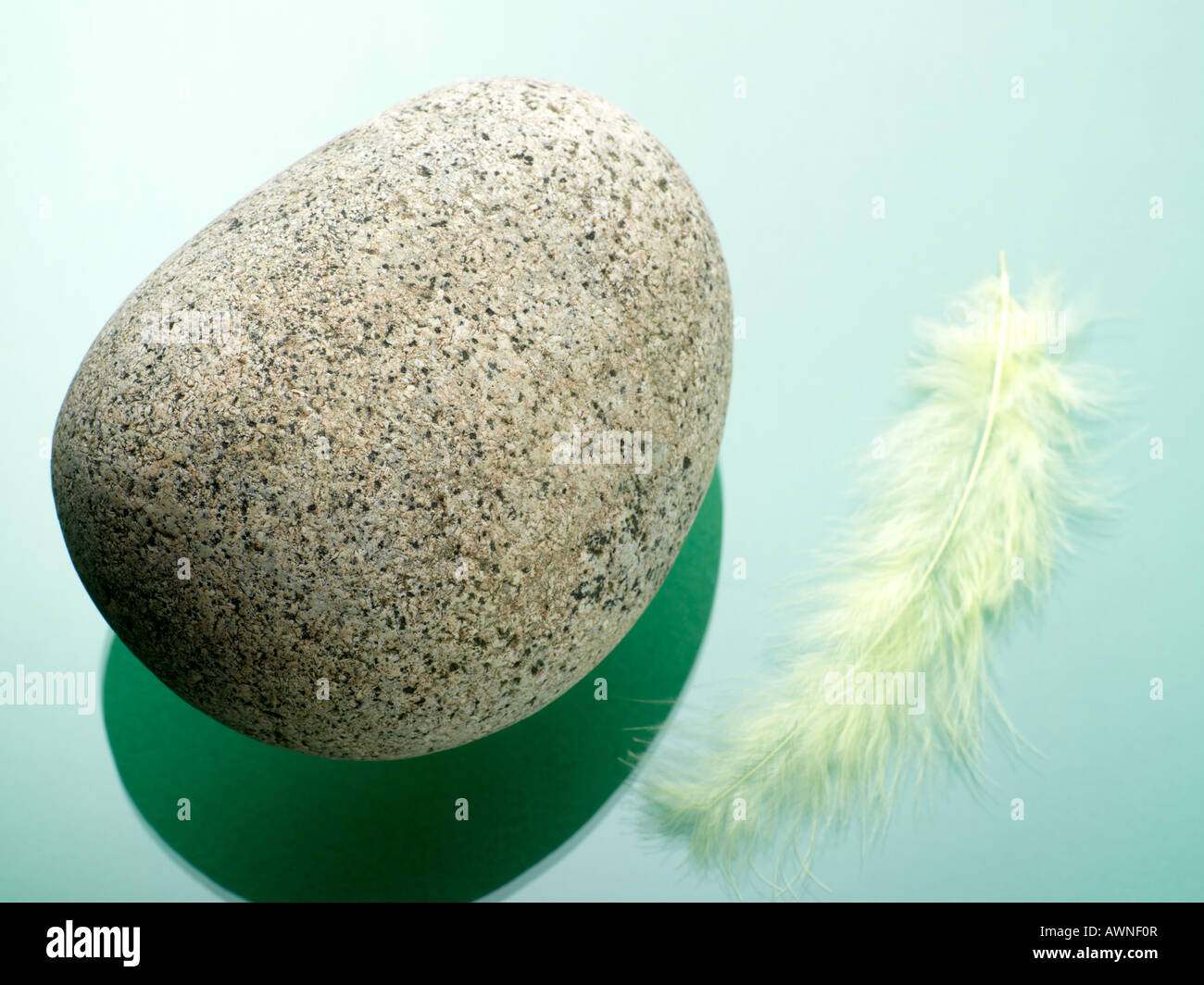 Stone and feather Stock Photo - Alamy