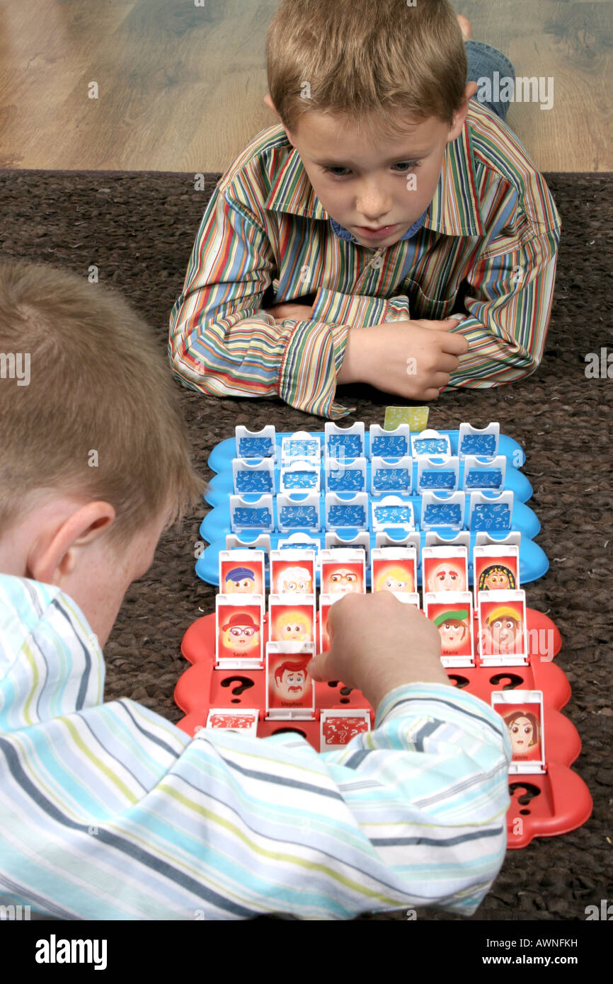 Two young boys playing a game of guess who together Stock Photo - Alamy