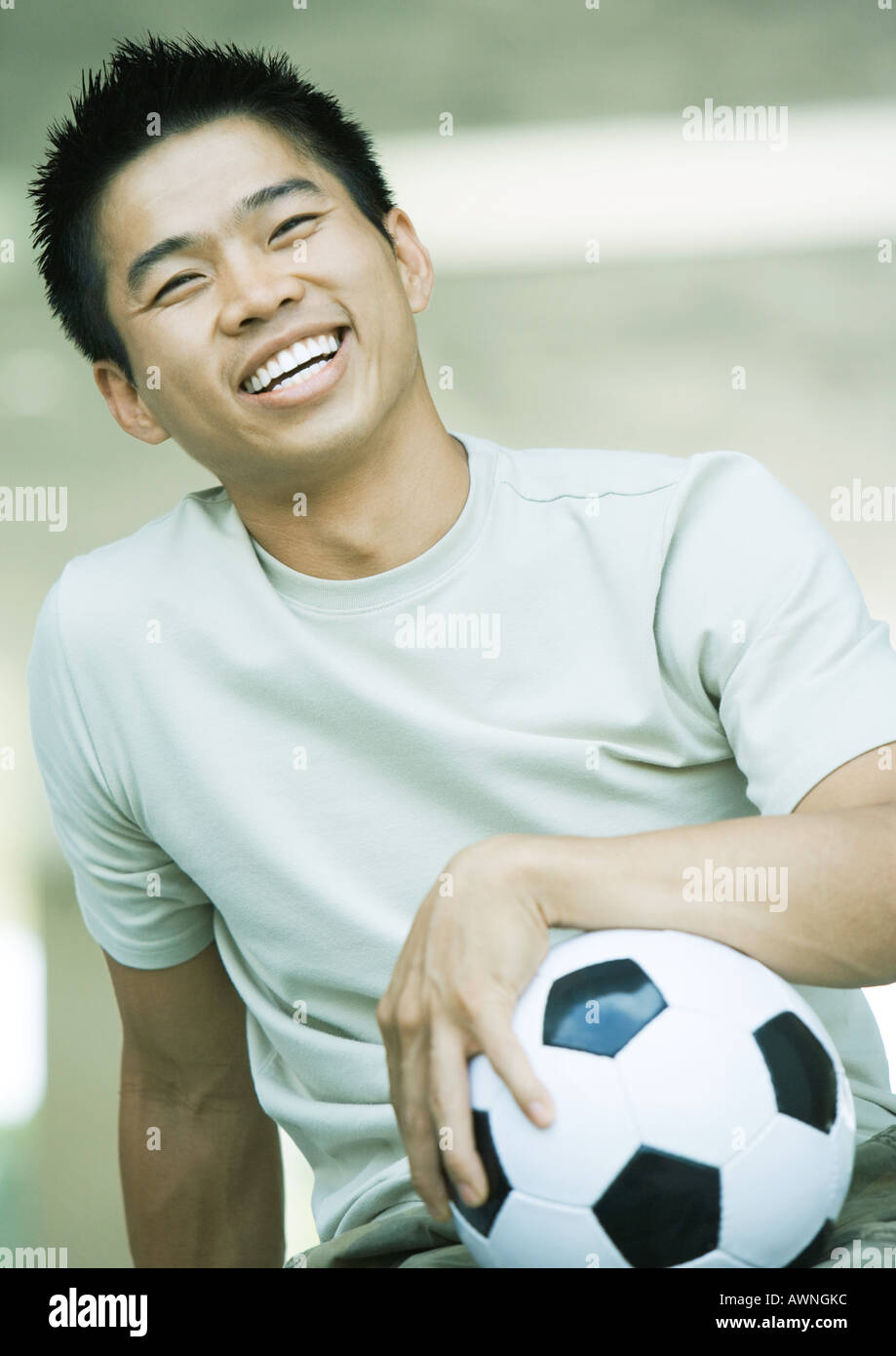 Young man with soccer ball, smiling Stock Photo - Alamy