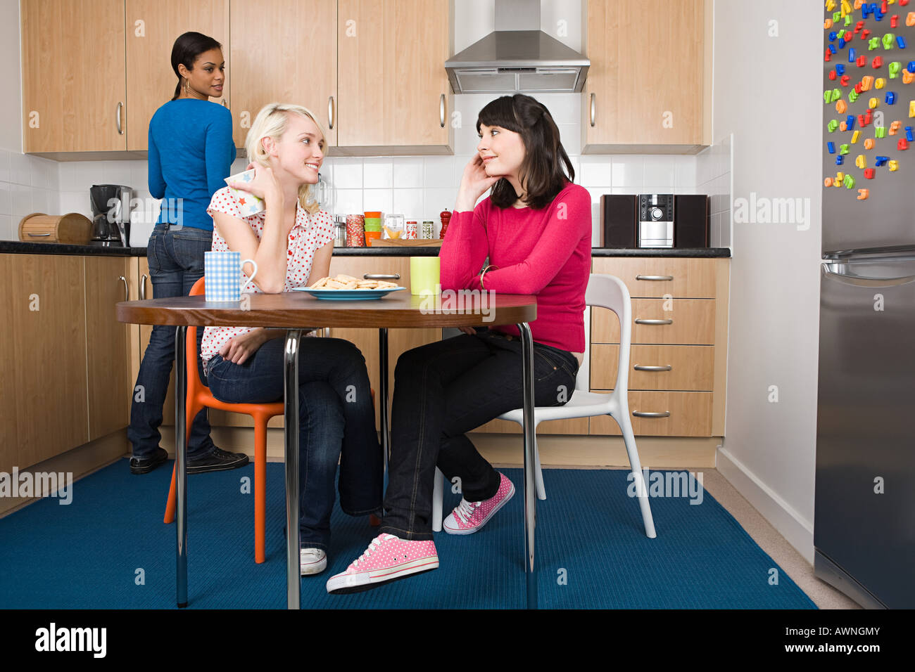 Three flatmates in a kitchen Stock Photo - Alamy