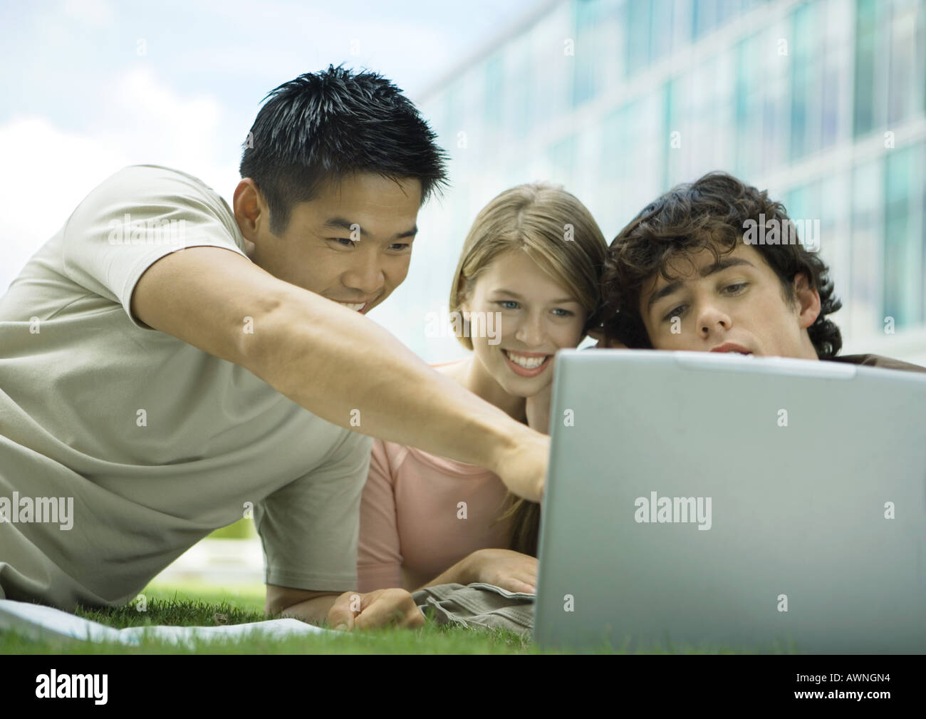 Three college students using laptop outdoors Stock Photo - Alamy