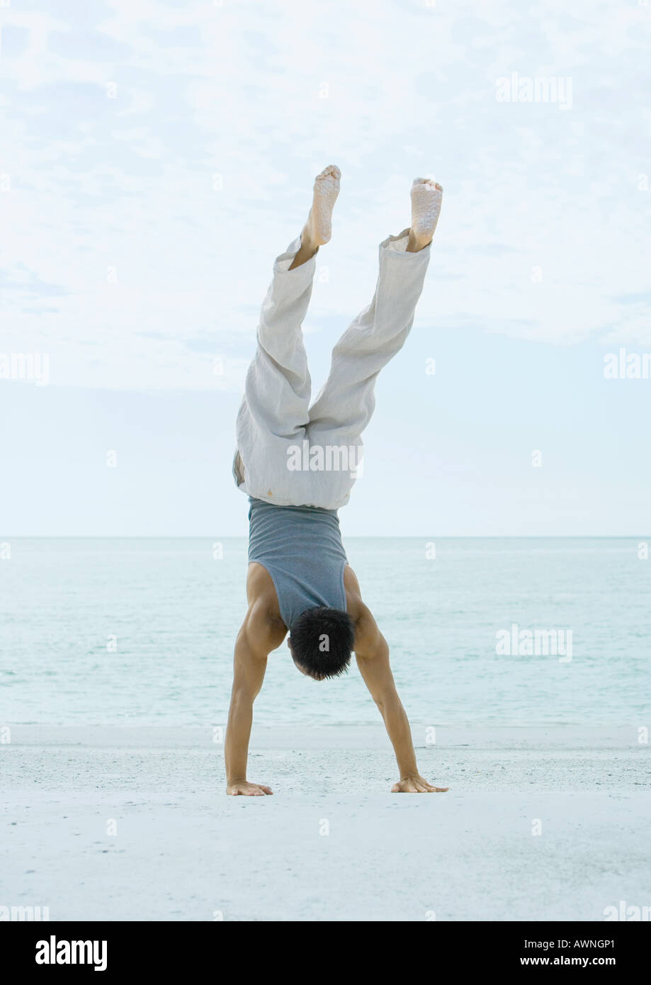 Man doing handstand on beach Stock Photo - Alamy
