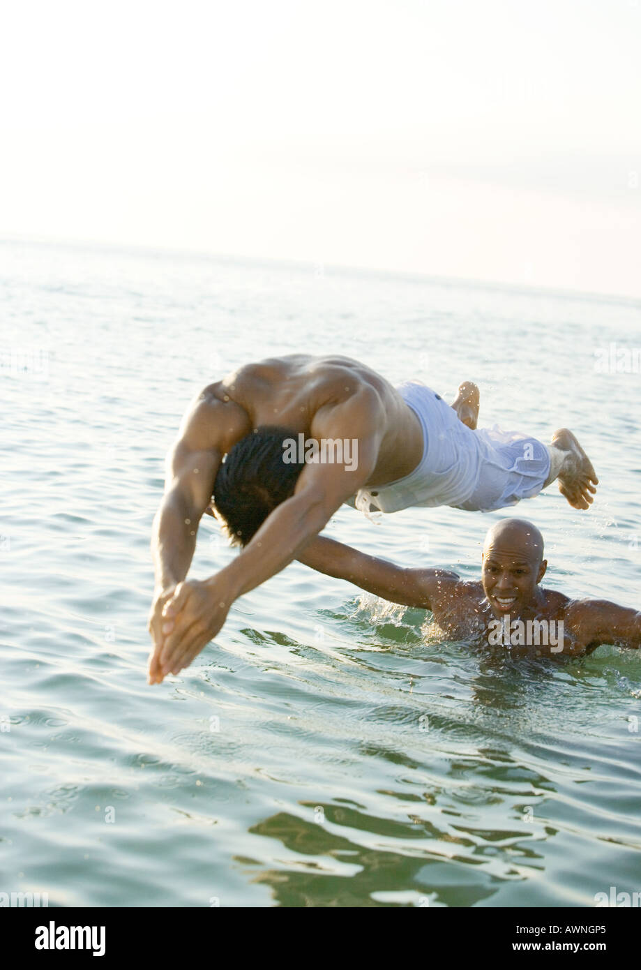Man diving into water from second man's shoulders Stock Photo - Alamy