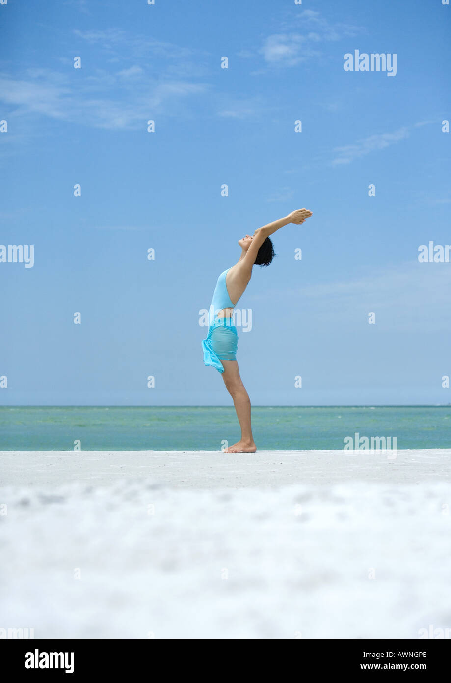 Woman performing sun salutation on beach Stock Photo - Alamy