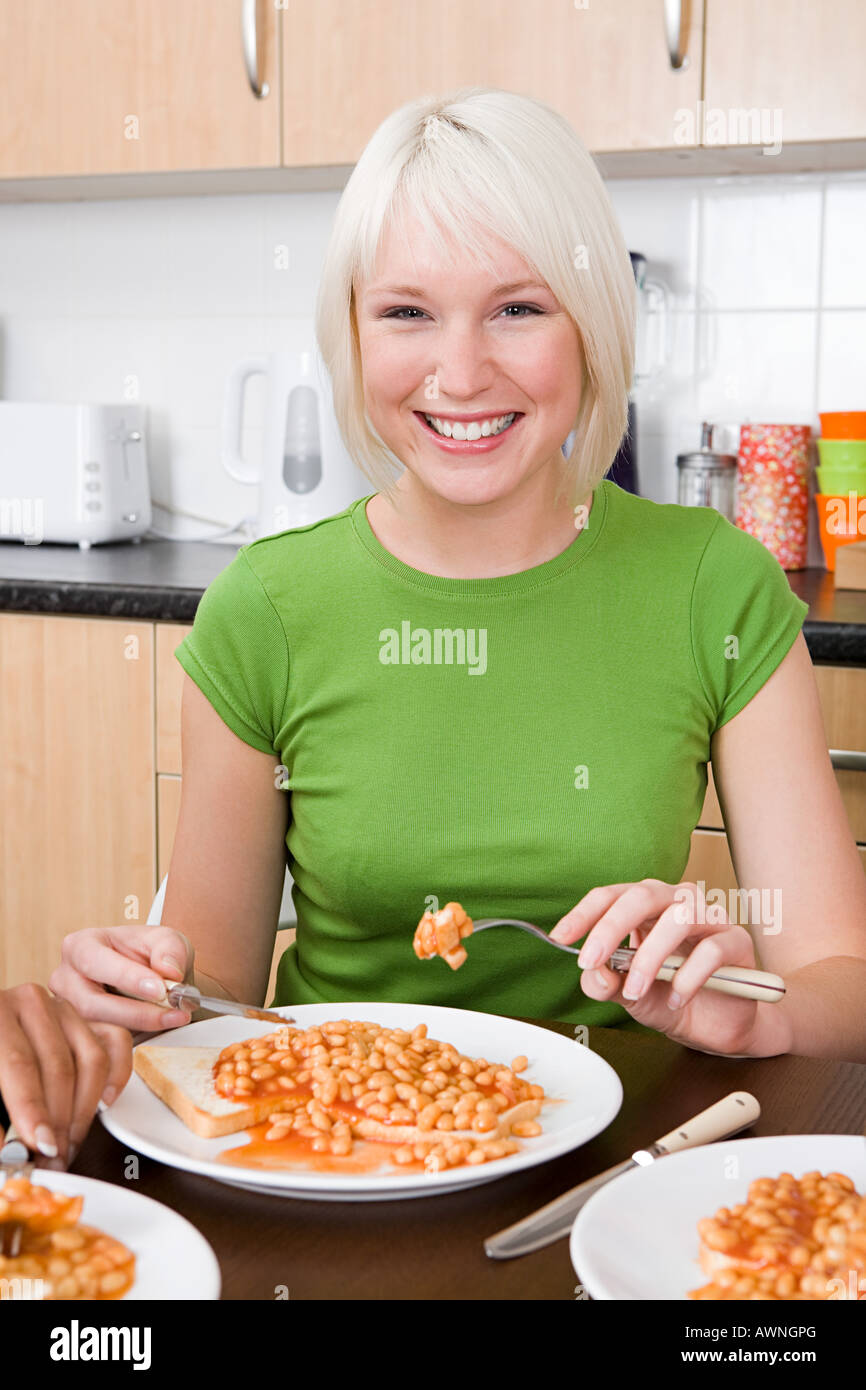 Young woman eating beans on toast Stock Photo - Alamy