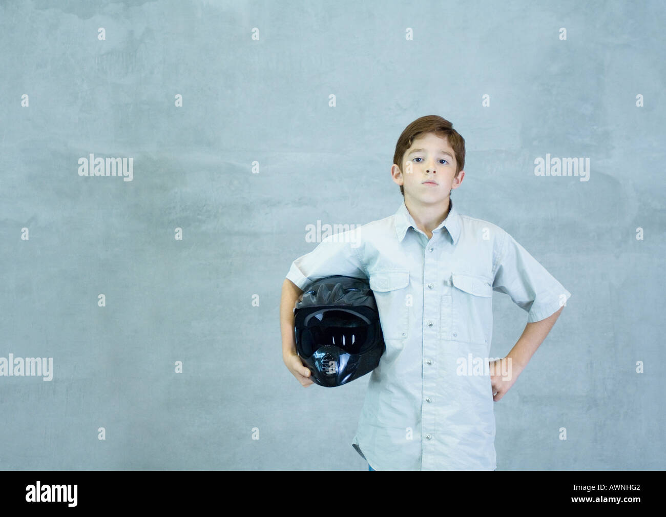 Boy standing with helmet under arm Stock Photo - Alamy