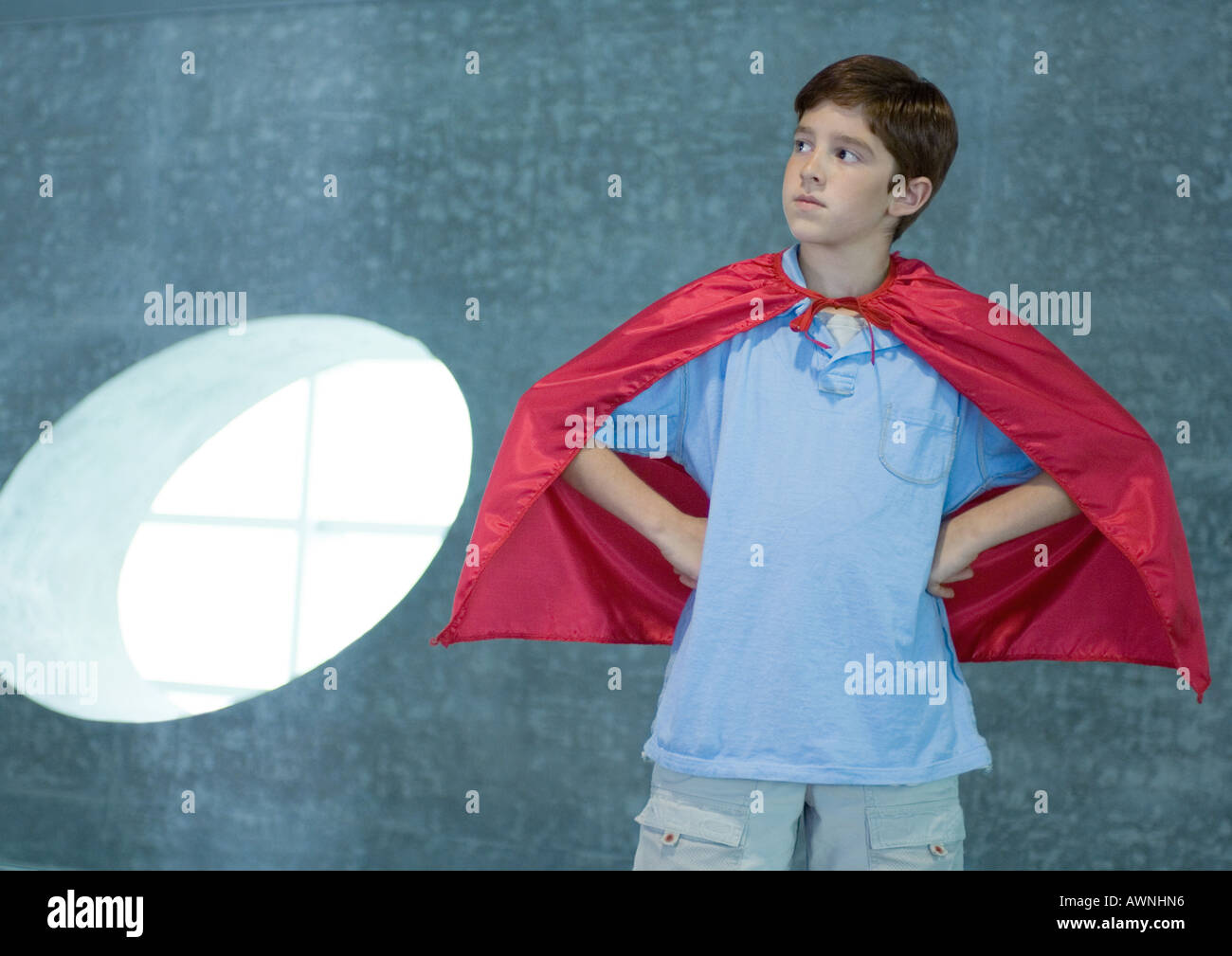Boy wearing red cape, hands on hips Stock Photo - Alamy