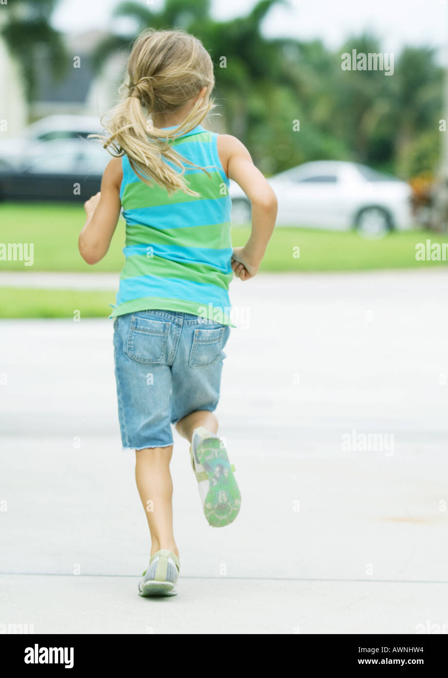 Girl running in suburban neighborhood Stock Photo - Alamy