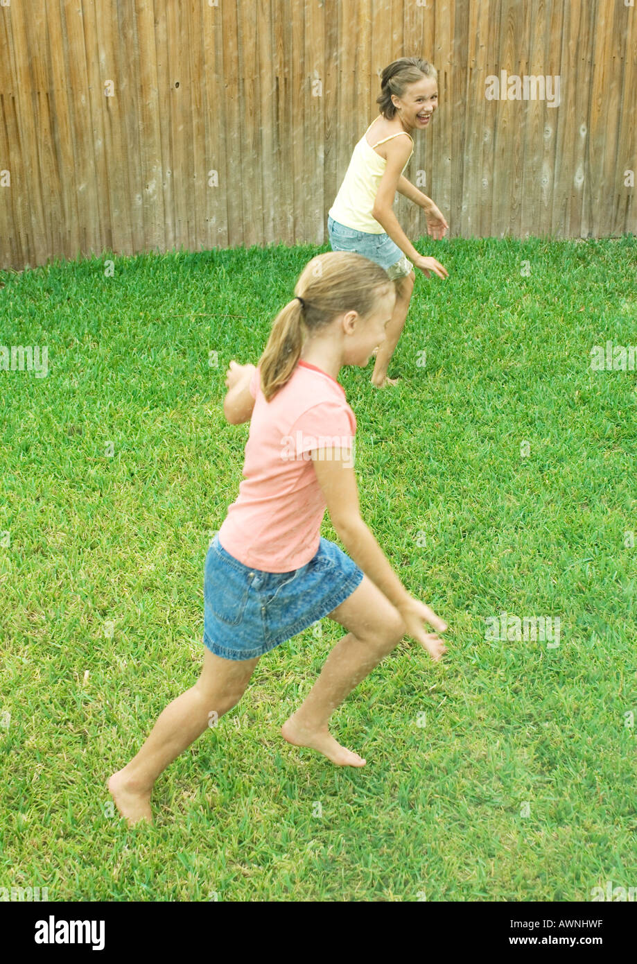 Girls running in yard Stock Photo - Alamy